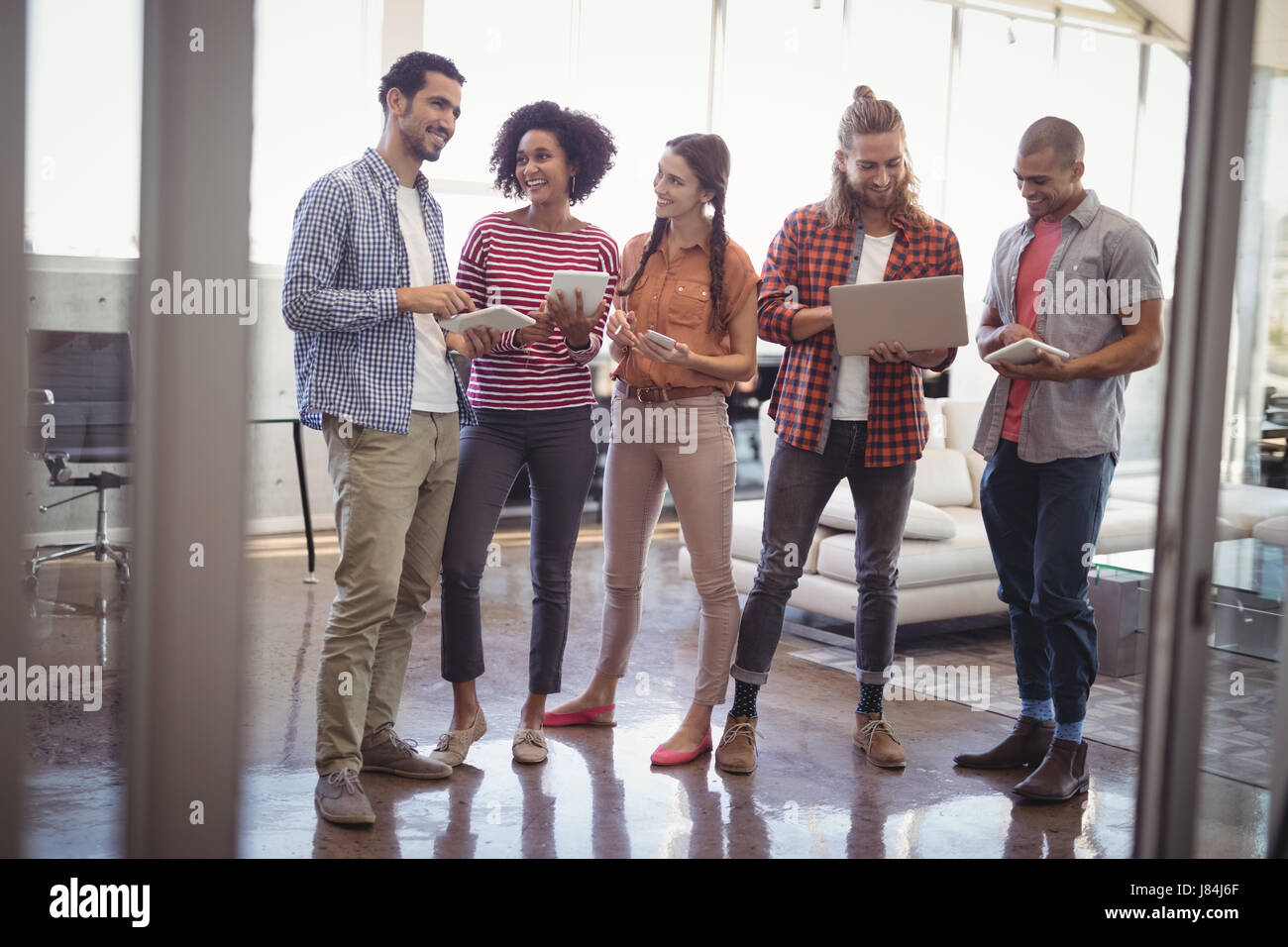 Young creative business people using laptop and digital tablets at ...
