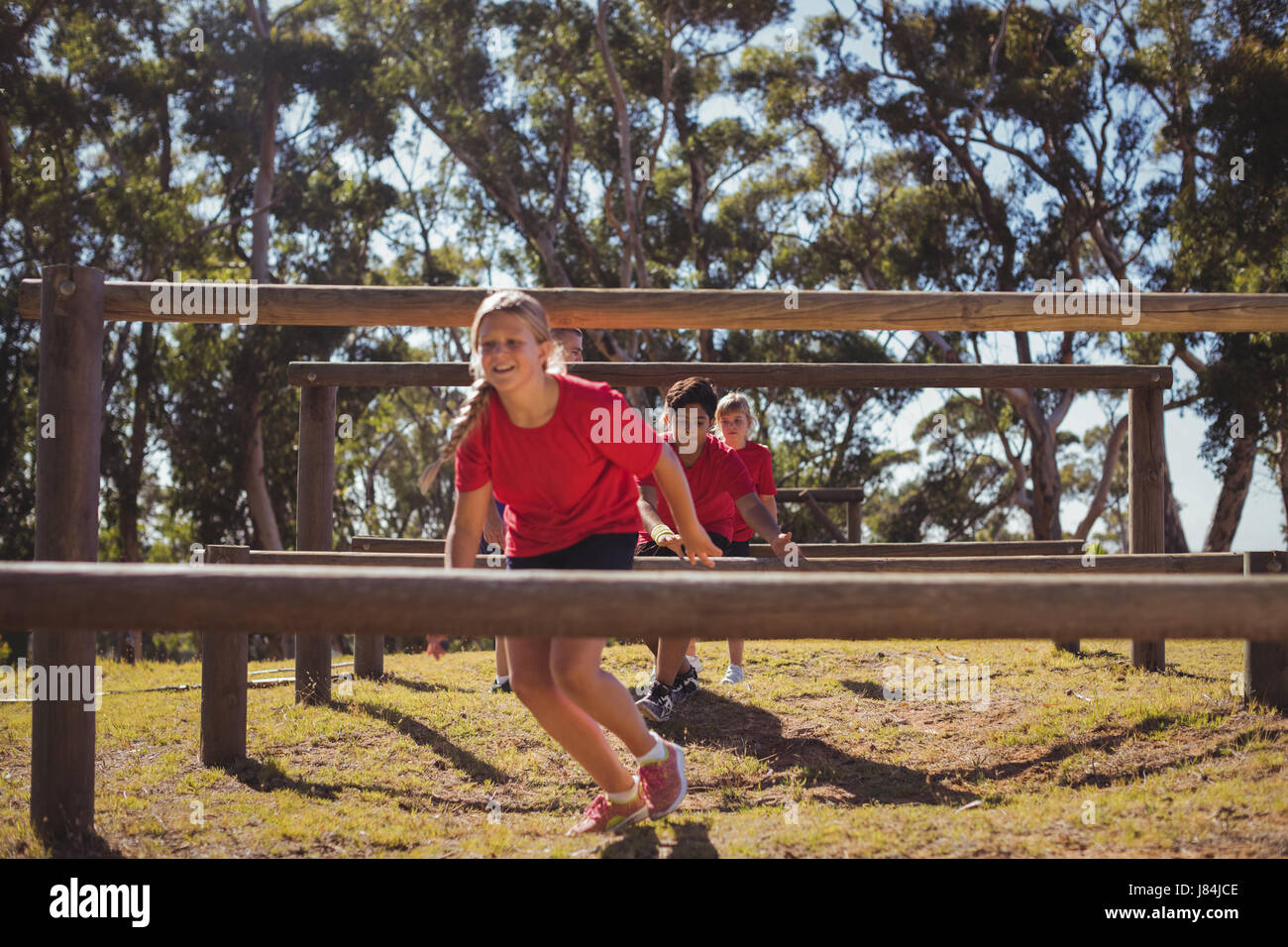 Kids jumping over the hurdles during obstacle course training in the ...