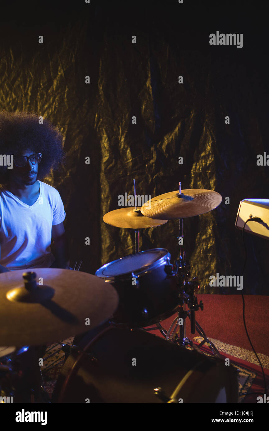 Confident male drummer performing in illuminated nightclub Stock Photo ...