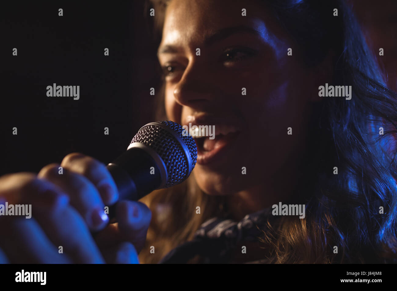 Close up of enthusiastic female singer performing in nightclub Stock ...
