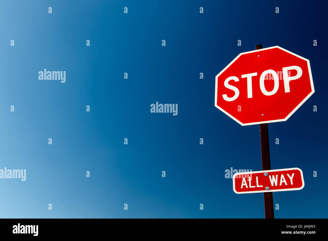All way stop sign against bright blue sky Stock Photo - Alamy