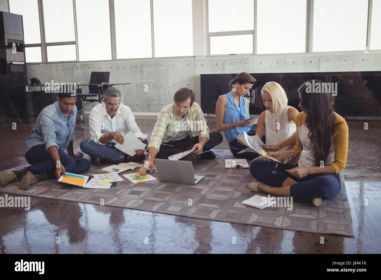Group of creative business people using charts and laptop while working ...