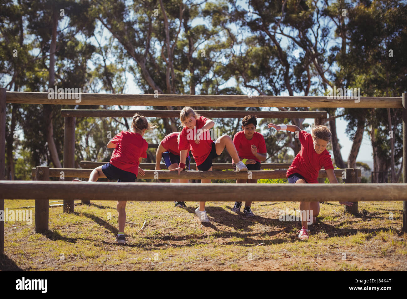 Kids jumping over the hurdles during obstacle course training in the ...