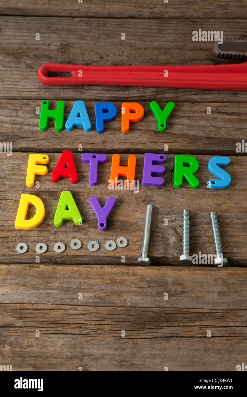 High angle view of happy fathers day text with pipe wrench and bolts on ...