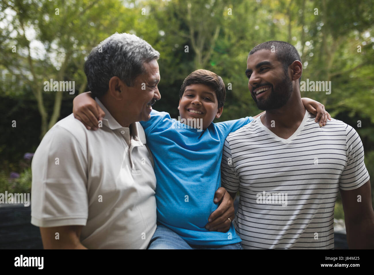 Happy multi-generation family against trees at park Stock Photo - Alamy