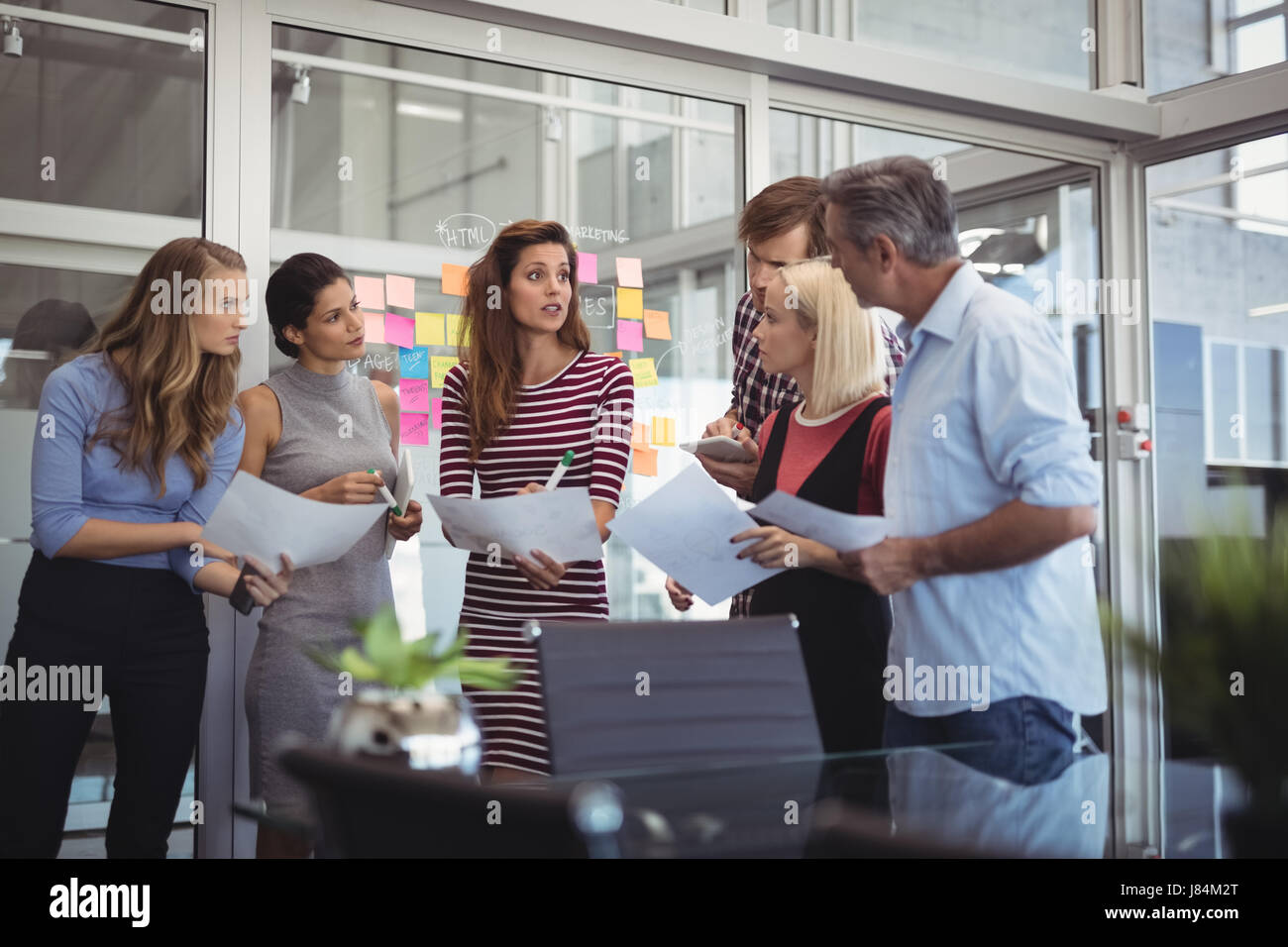 Low angle view of business people with papers having discussion in ...