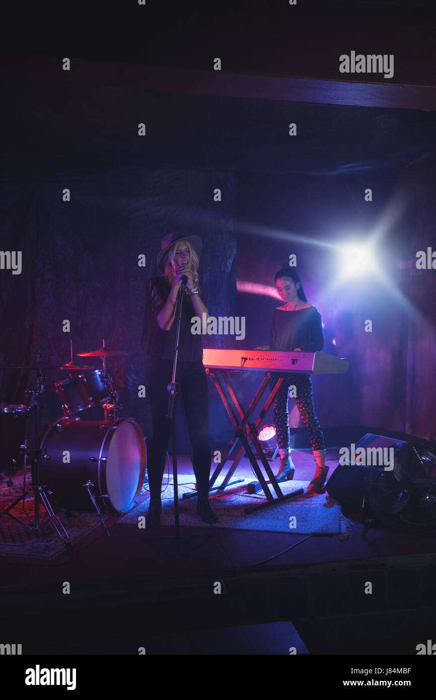 Confident female performers performing on illuminated stage in ...
