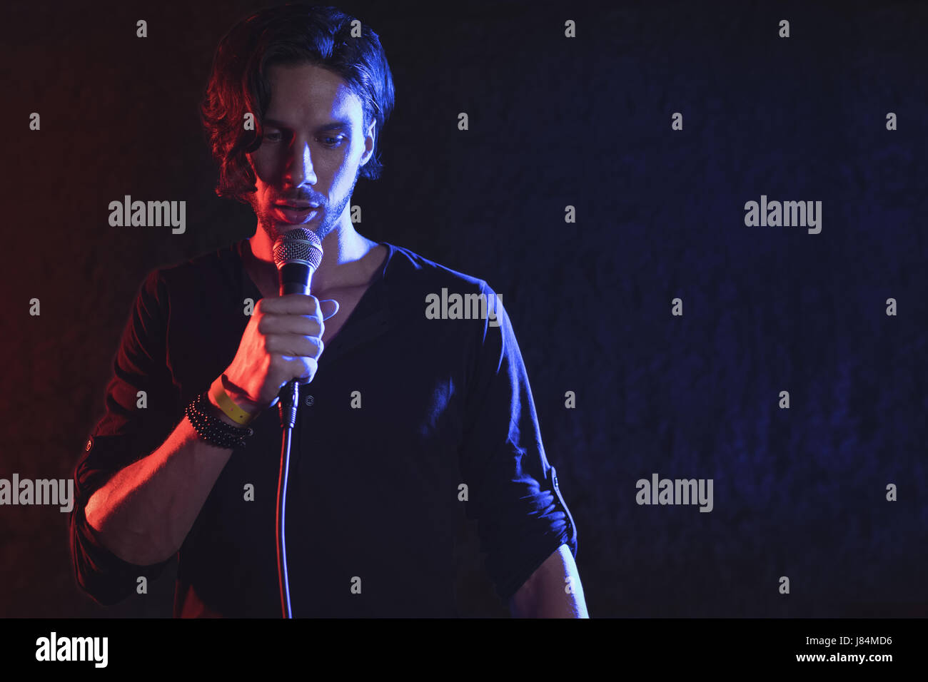 Confident male singer performing at music concert Stock Photo - Alamy