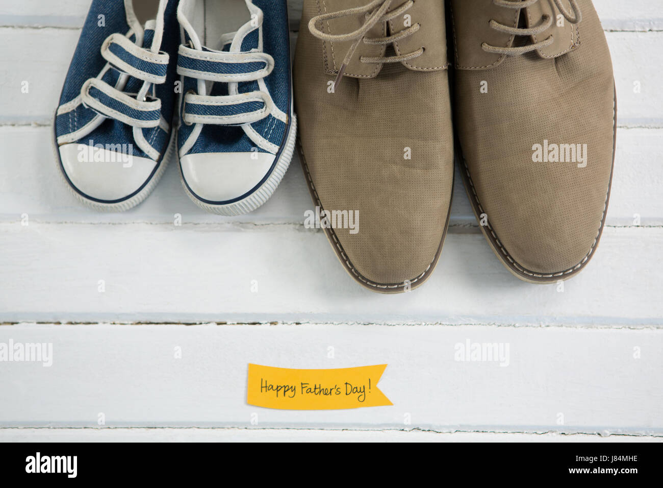 Overhead view of shoes by text on white table Stock Photo - Alamy