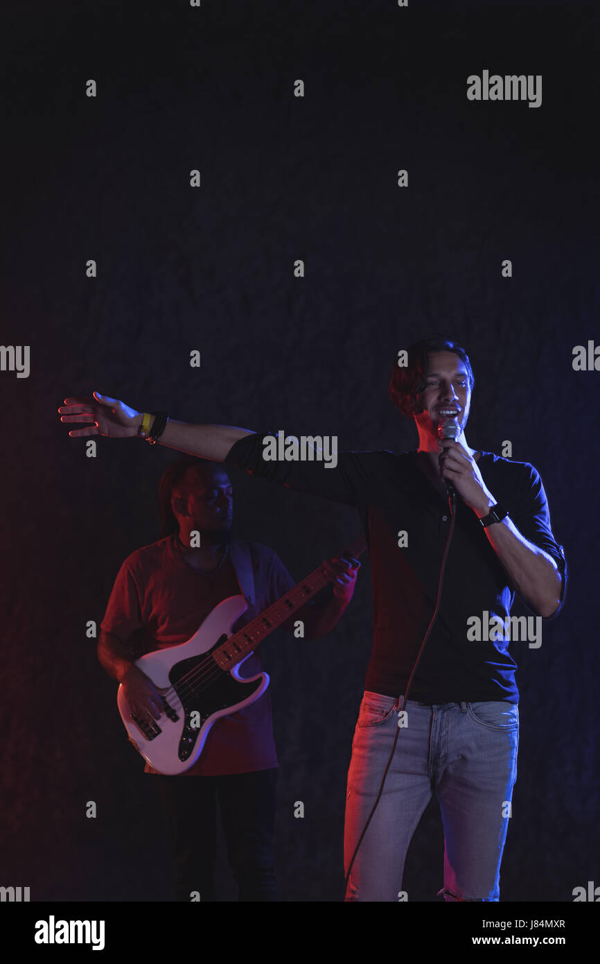 Enthusiastic singer with guitarist performing in music concert Stock ...