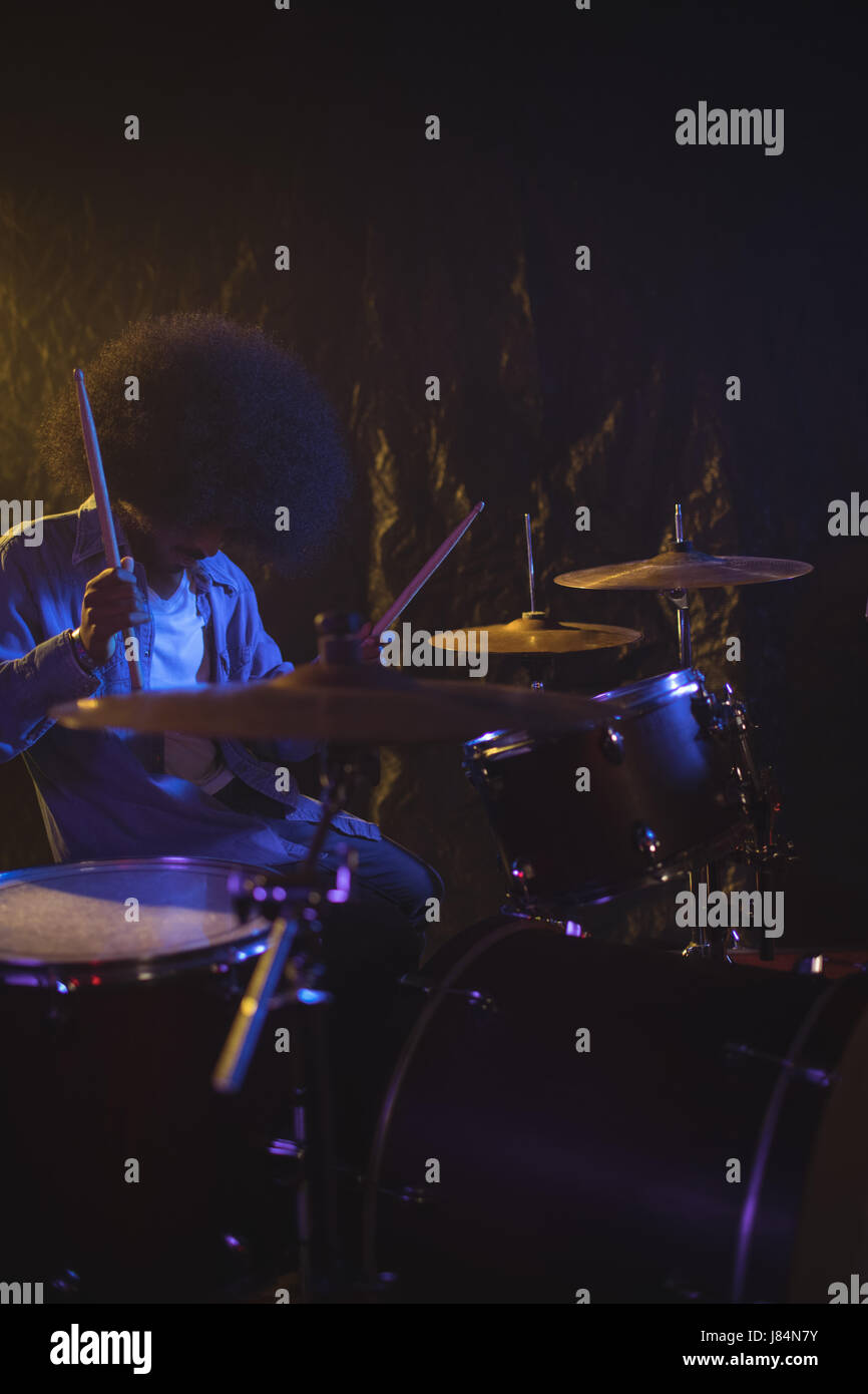 Male drummer with frizzy hair playing drum kit in nightclub Stock Photo ...