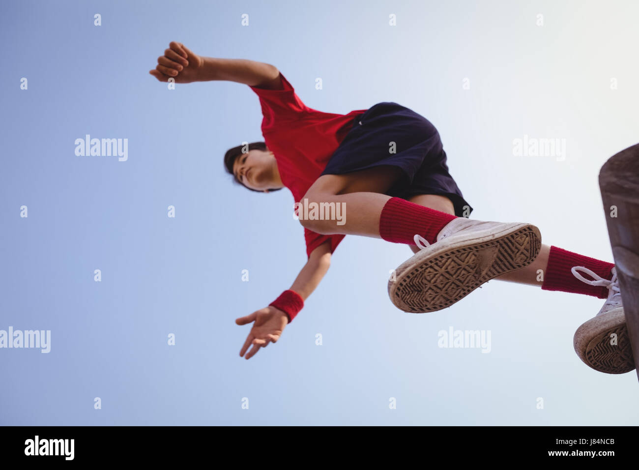 Determined boy jumping over obstacle in boot camp Stock Photo - Alamy