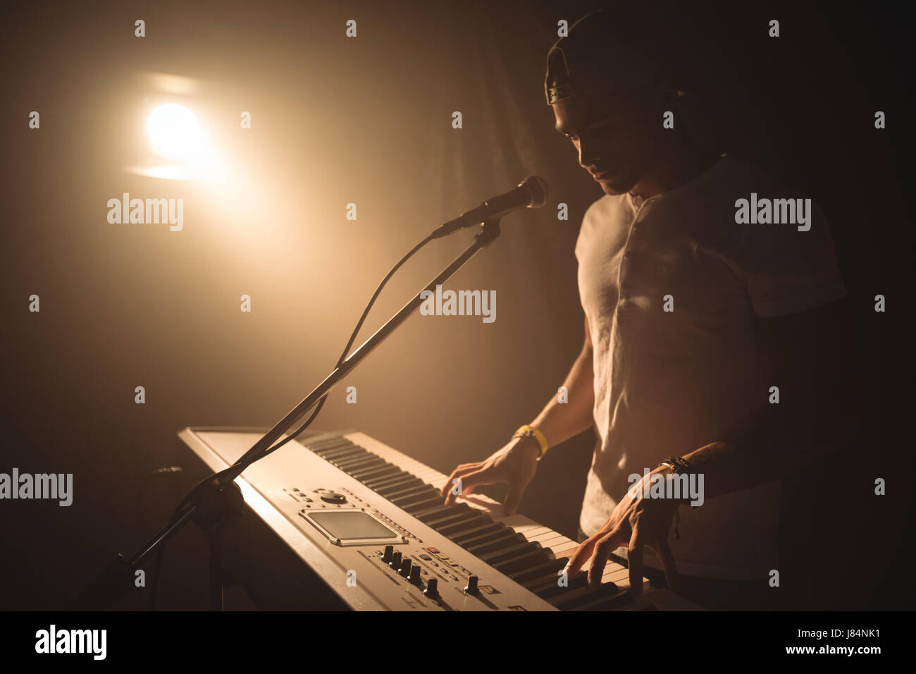 Confident male singer playing piano in nightclub Stock Photo - Alamy
