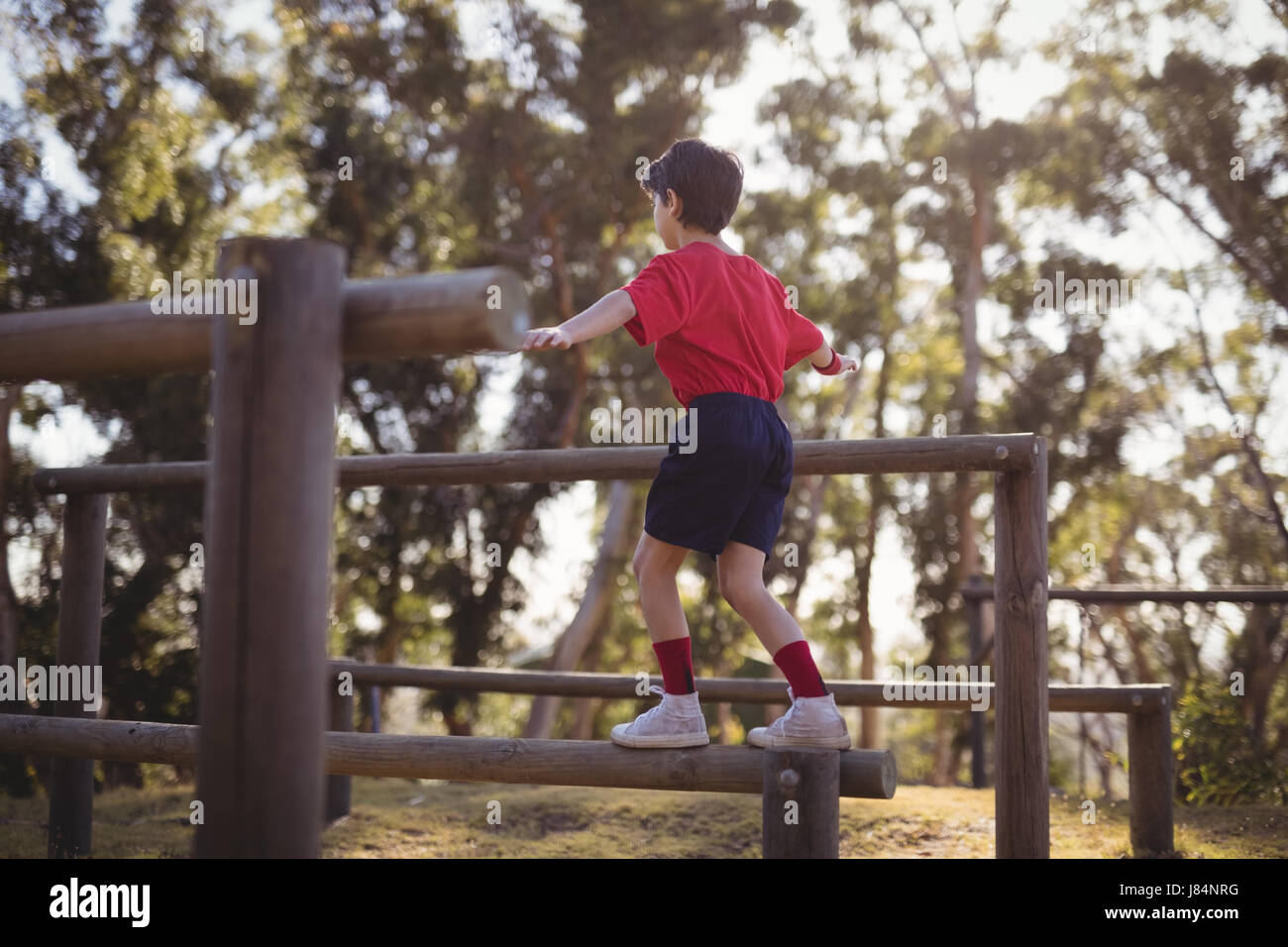 Boy walking on obstacle during obstacle course in boot camp Stock Photo ...