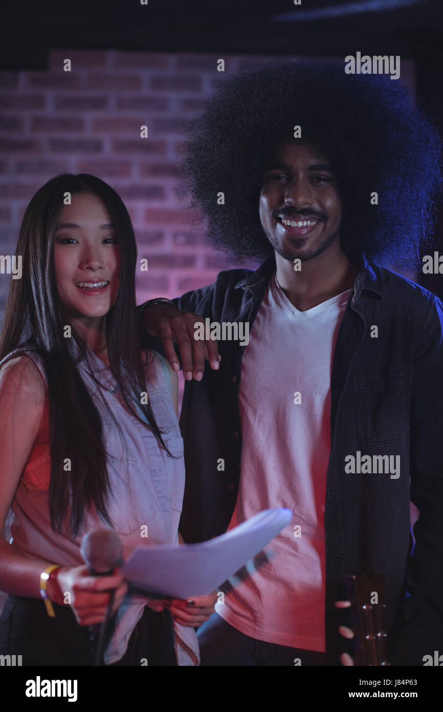 Portrait of singer and guitarist holding paper in nightclub Stock Photo ...
