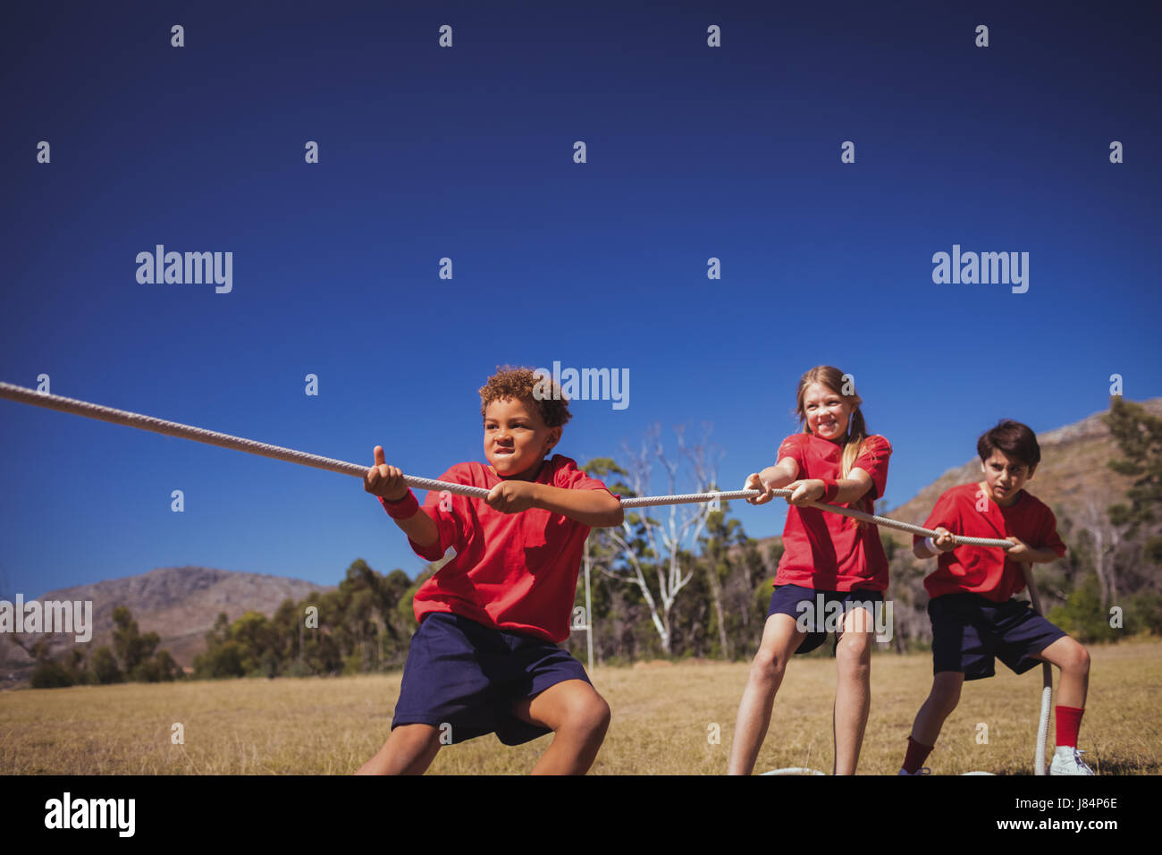 Kids playing tug of war during obstacle course training in the boot ...