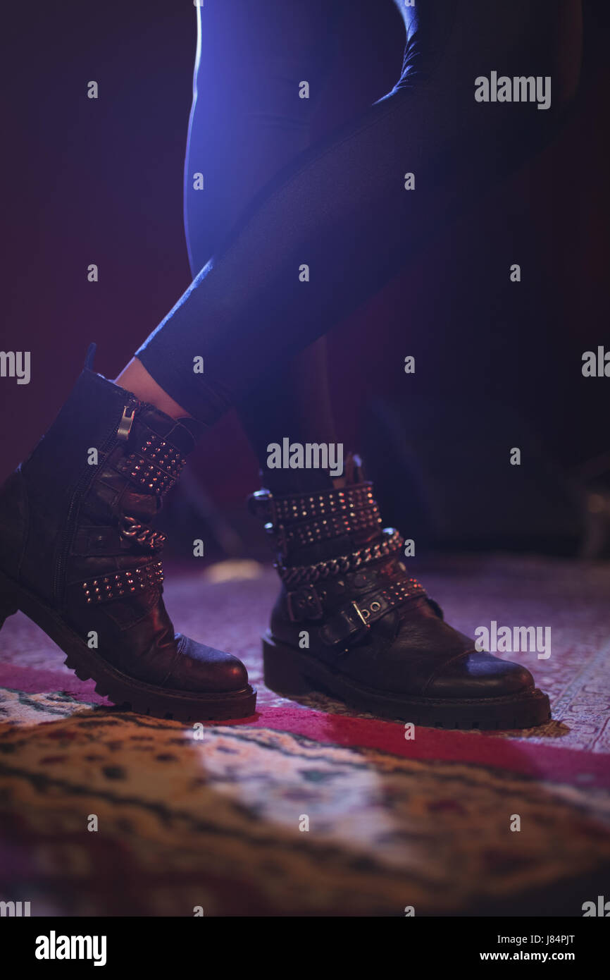 Low section of female singer wearing shoes while standing on carpet ...