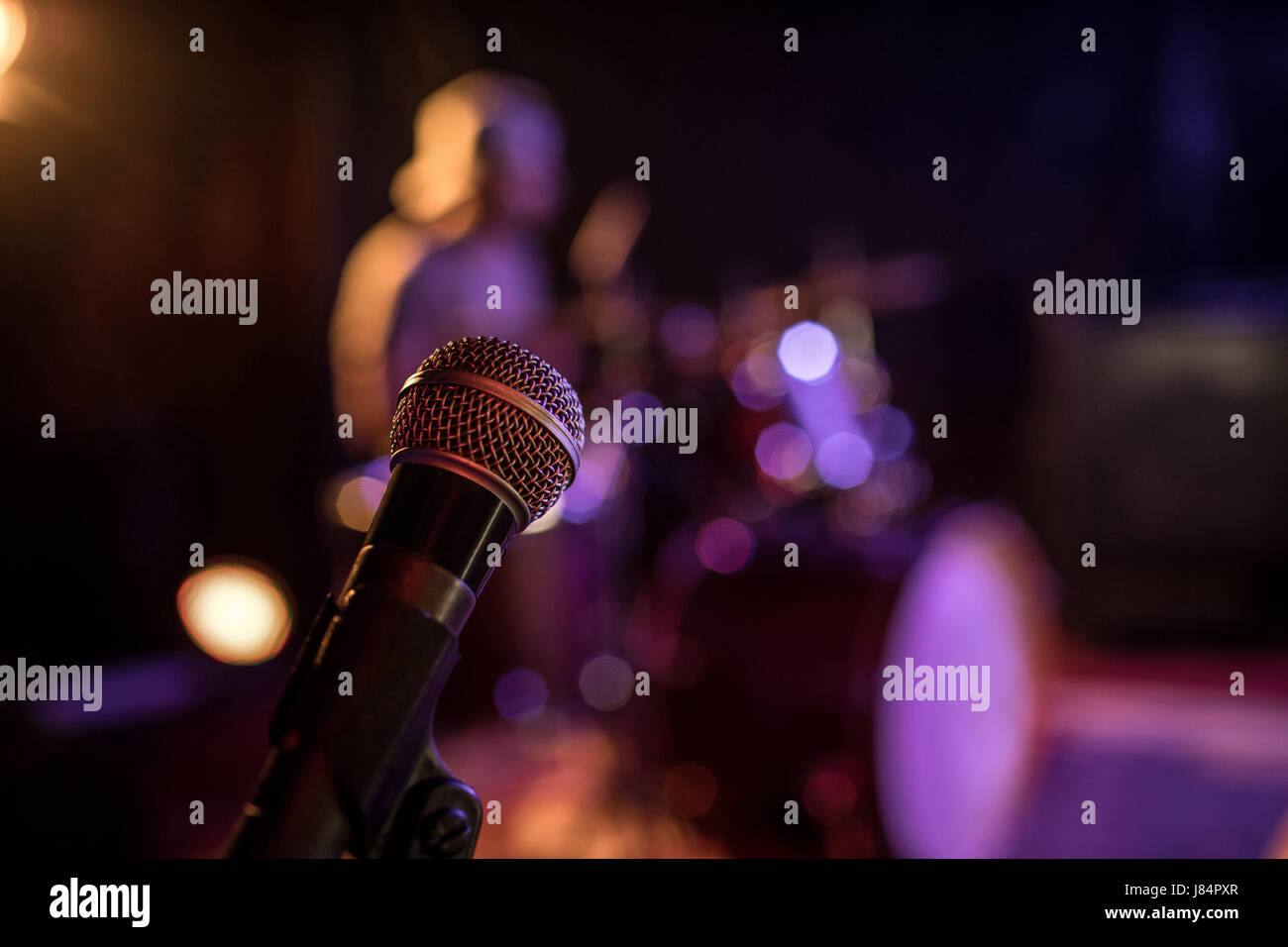 Close up of microphone in illuminated nightclub Stock Photo - Alamy
