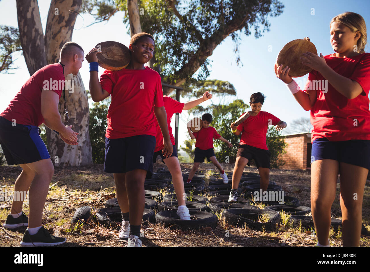 Trainer instructing kids during obstacle course training in the boot ...
