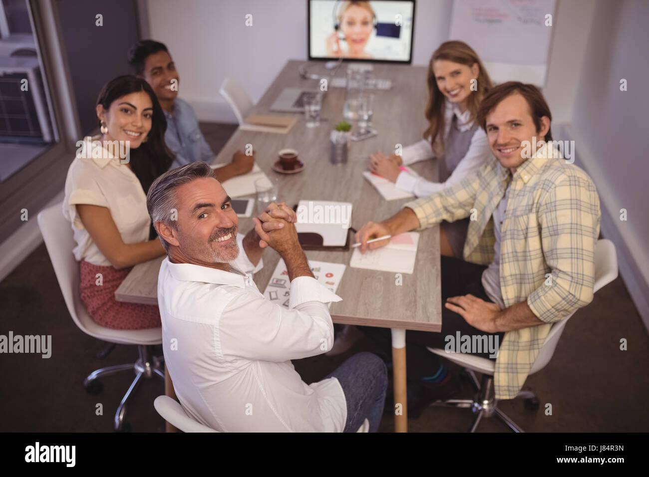 Portrait of smiling business people attending video conference meeting ...