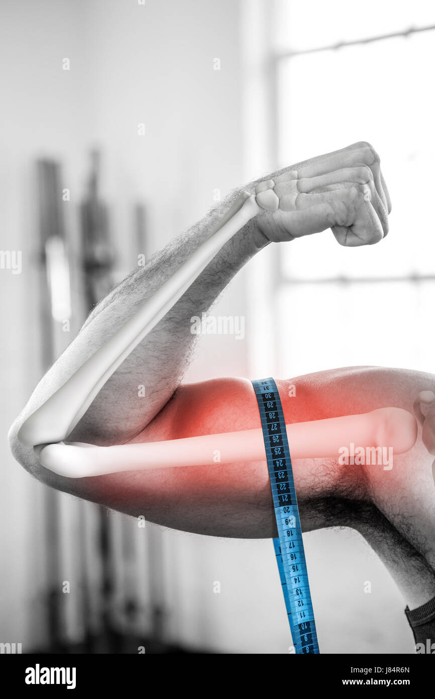 Digital composite of highlighted arm of man measuring biceps with ...
