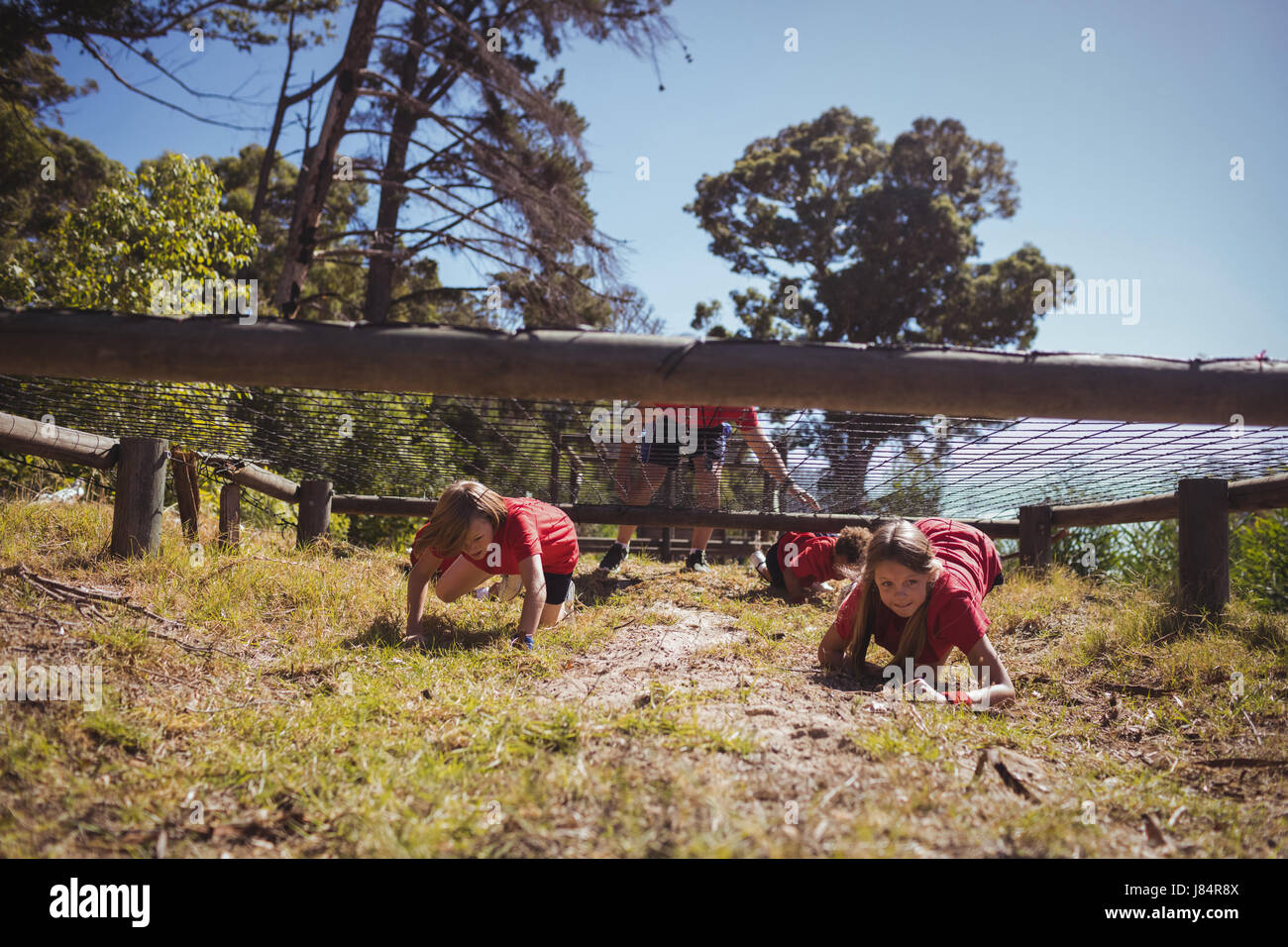 Kids crawling under the net during obstacle course training in the boot ...