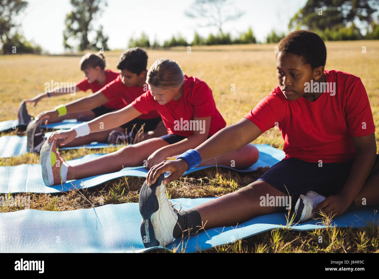 Group of kids exercising in the boot camp on a sunny day Stock Photo ...