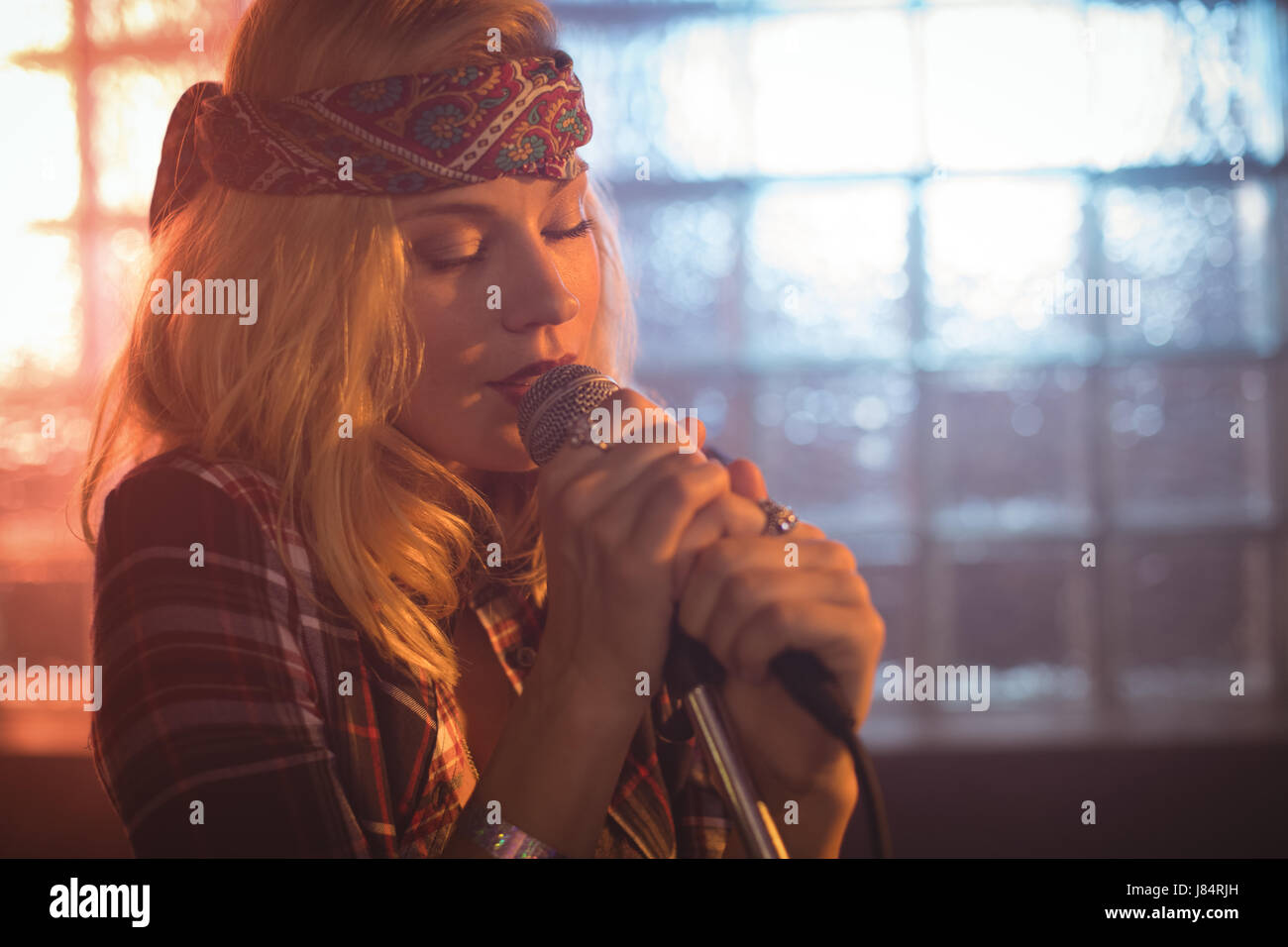 Close up of beautiful female singer performing in illuminated nightclub ...