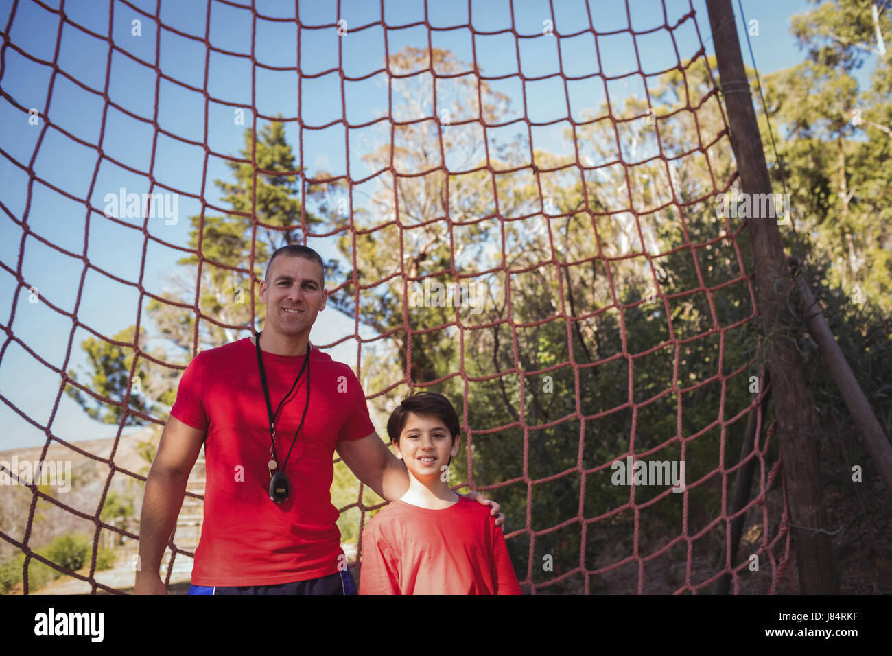 Portrait of trainer and boy standing together in the boot camp Stock ...