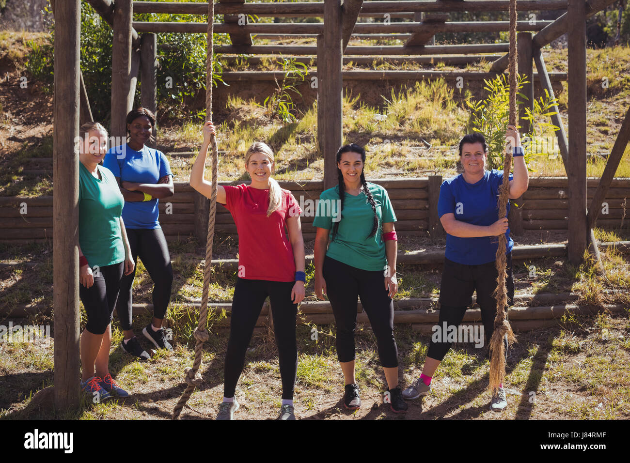 Group of fit women standing together in the boot camp on a sunny day ...