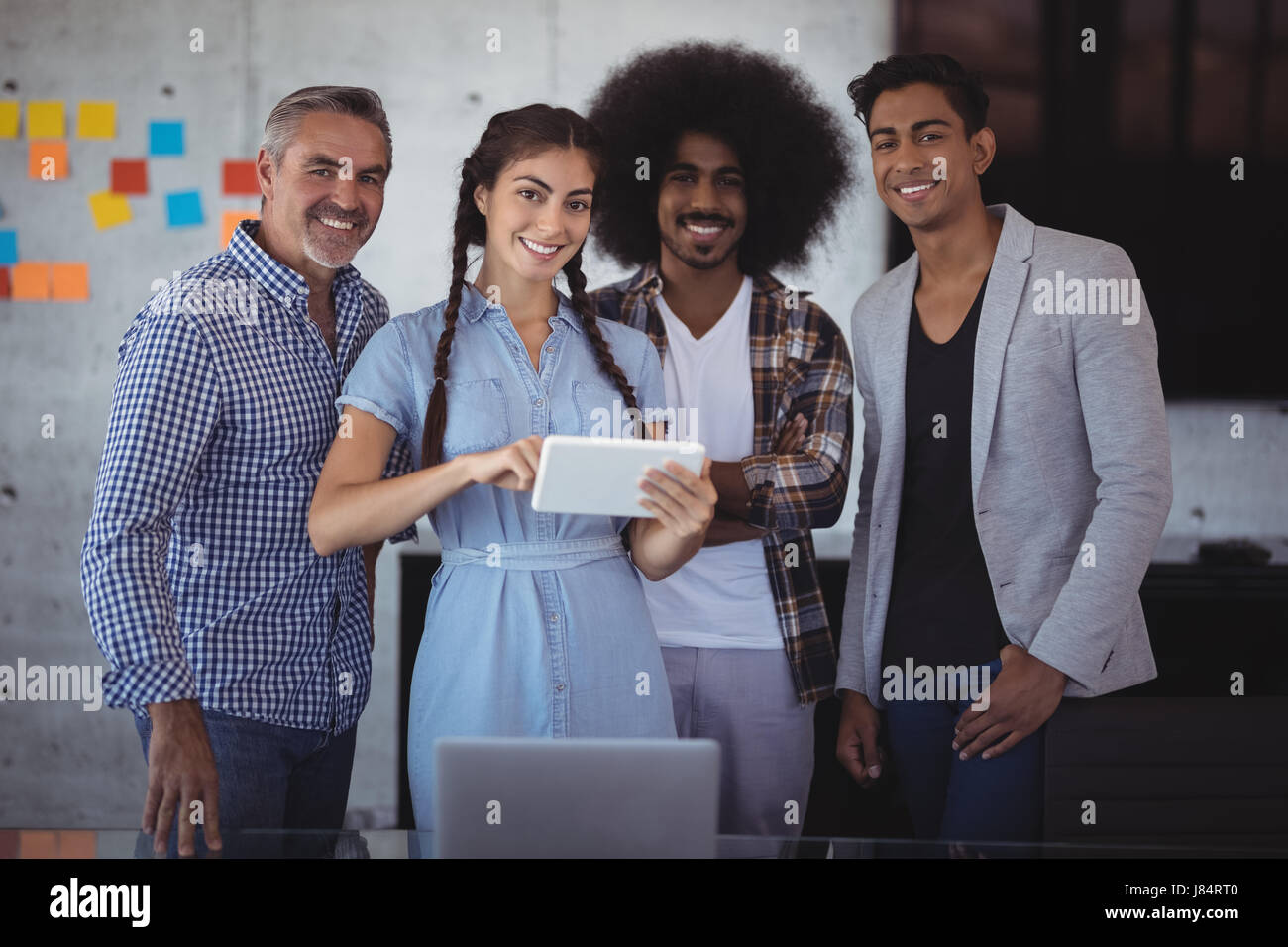 Portrait of smiling young businesswoman explaining over digital tablet ...