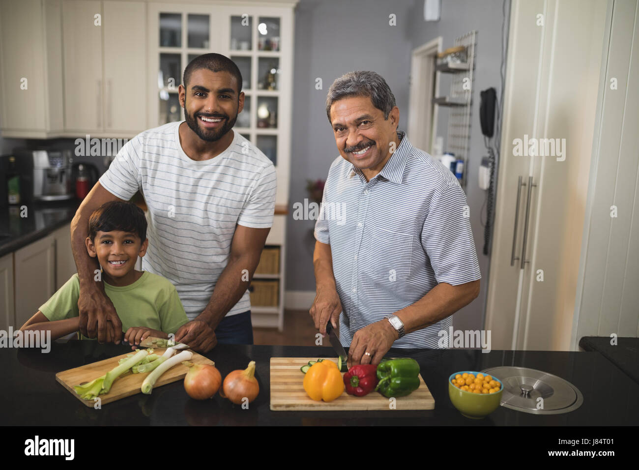 Portrait of happy multi-generation family preparing food together in ...