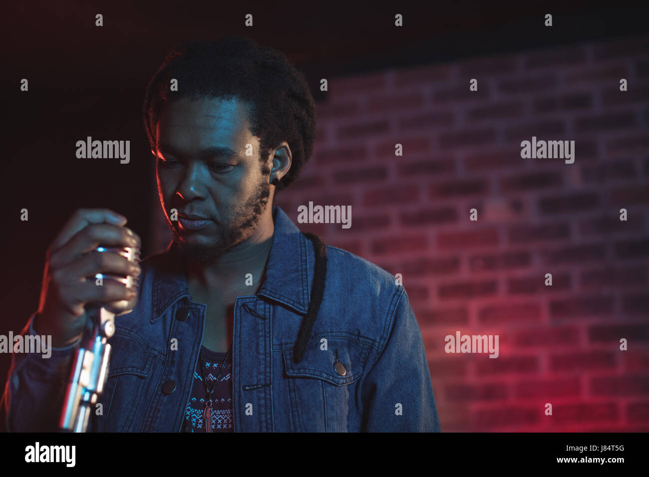 Close up of confident male singer holding microphone in nightclub Stock ...