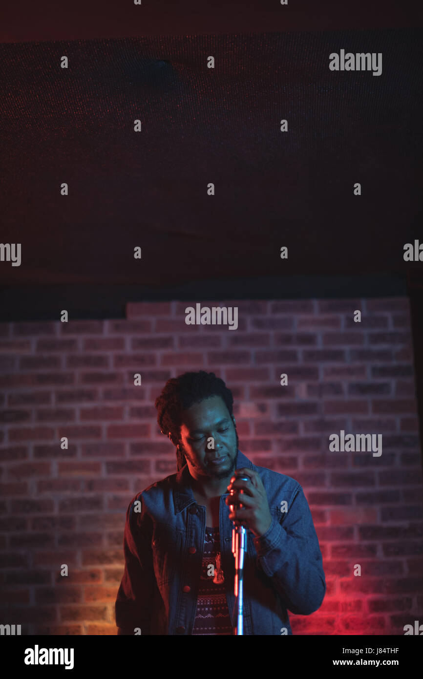 Confident male singer performing in nightclub Stock Photo - Alamy