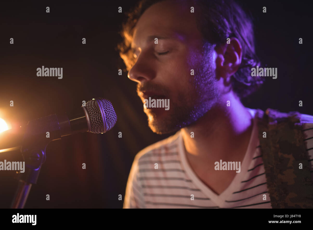 Close up of male singer performing in illuminated nightclub Stock Photo ...