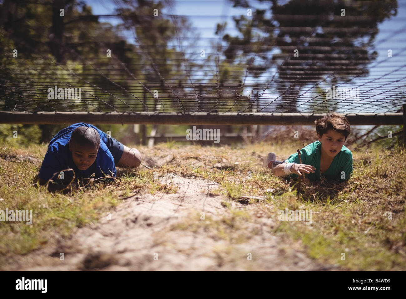Kids crawling under the net during obstacle course in boot camp Stock ...