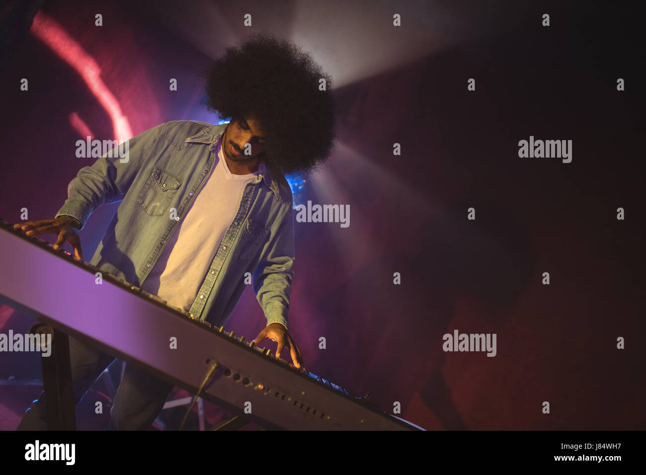 Confident male musician playing piano on stage in nightclub Stock Photo ...