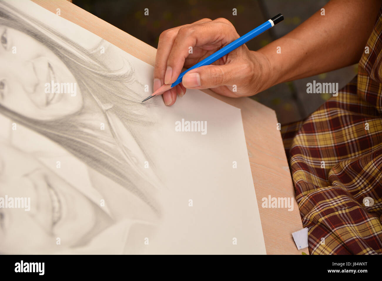 Female hand drawing man and woman smiling with pencil Stock Photo - Alamy