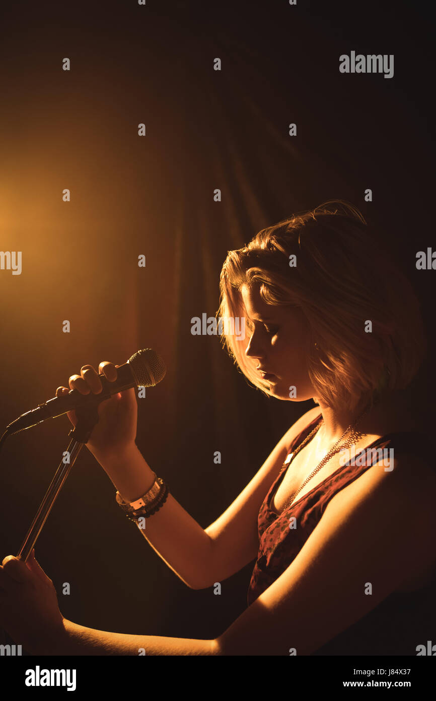 Confident female singer performing at music concert Stock Photo - Alamy
