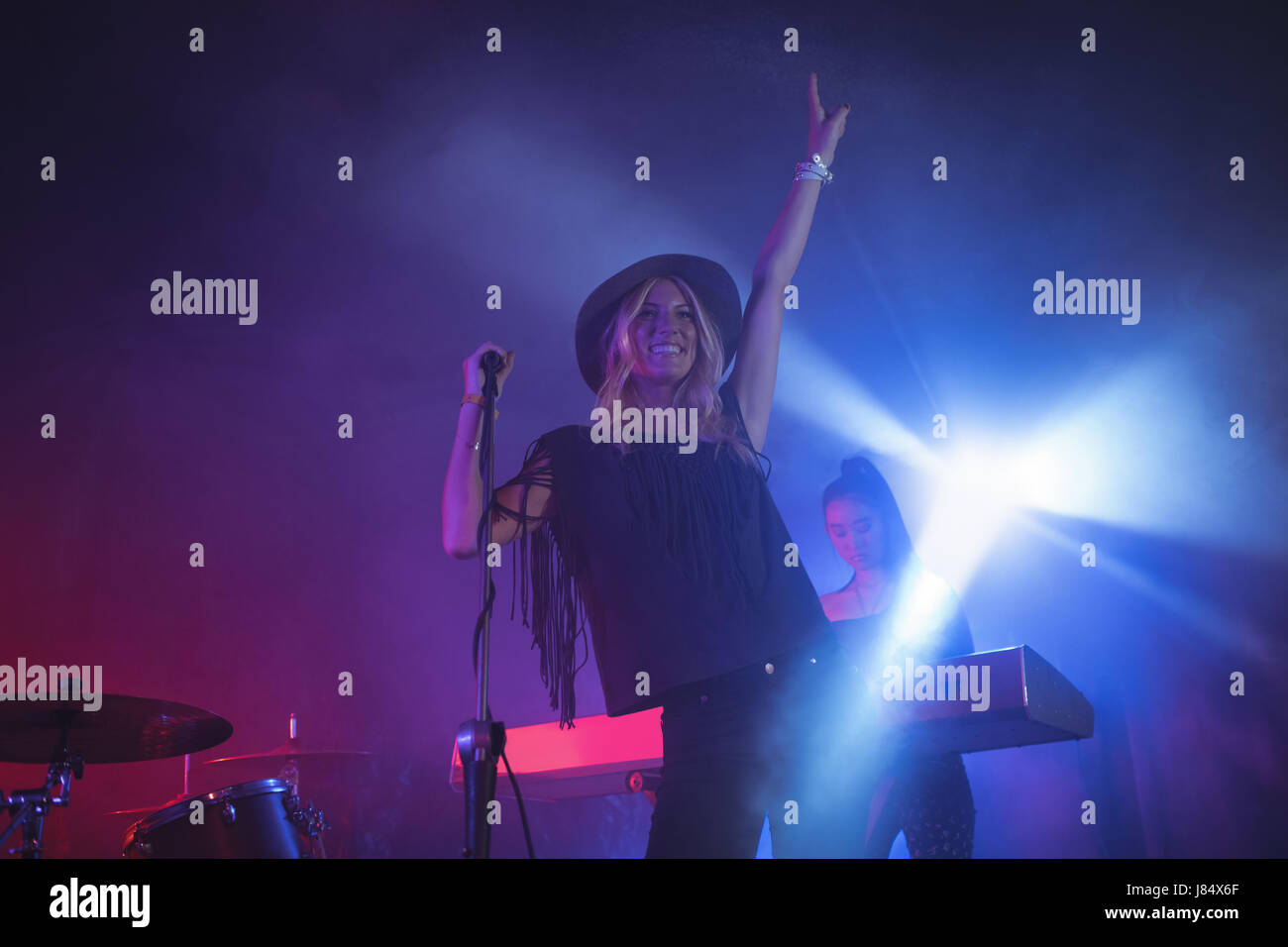 Low angle view of female singer singing while musician playing piano in ...