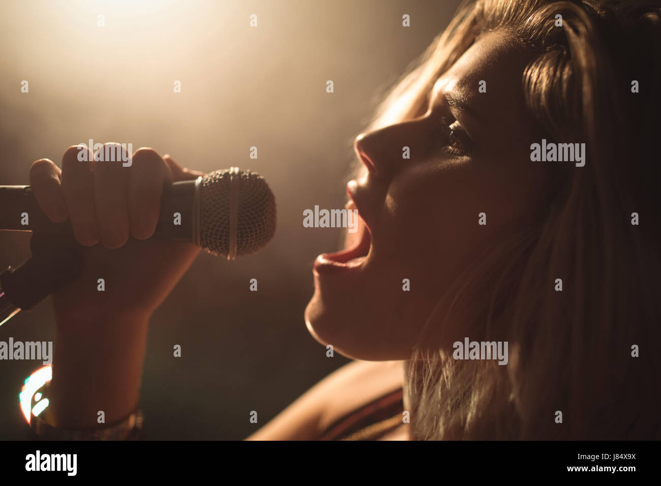 Close up of confident female singer performing in illuminated nightclub ...
