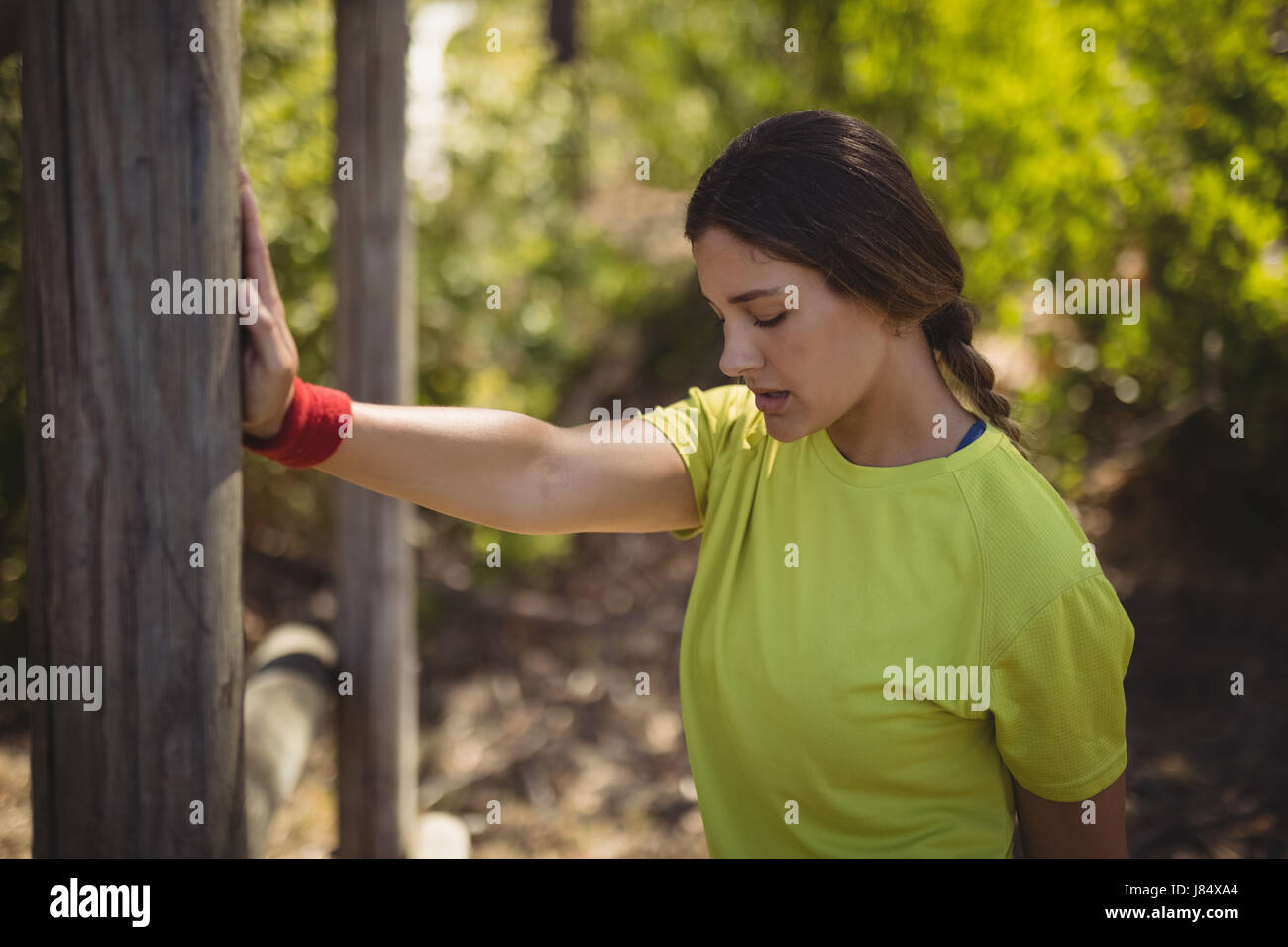 Beautiful woman performing exercising during obstacle course in boot ...