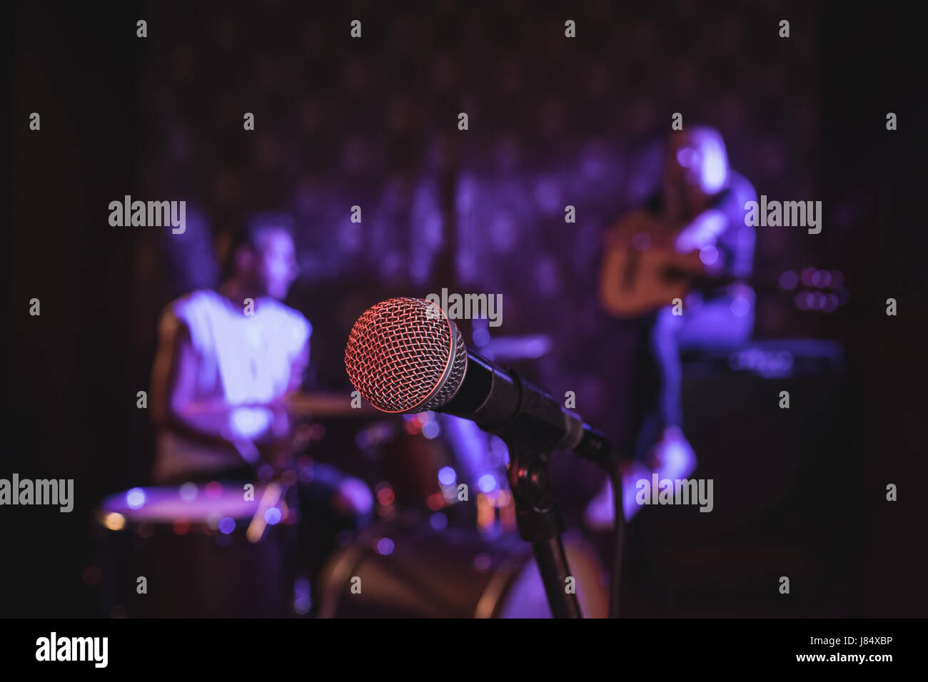 Close up of microphone with performers in background Stock Photo - Alamy