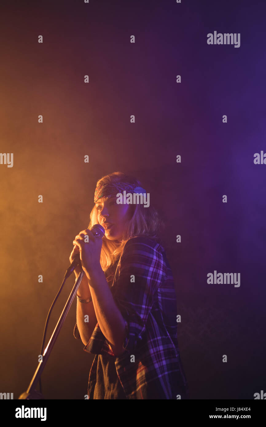 Low angle view of confident female singer performing in music concert ...