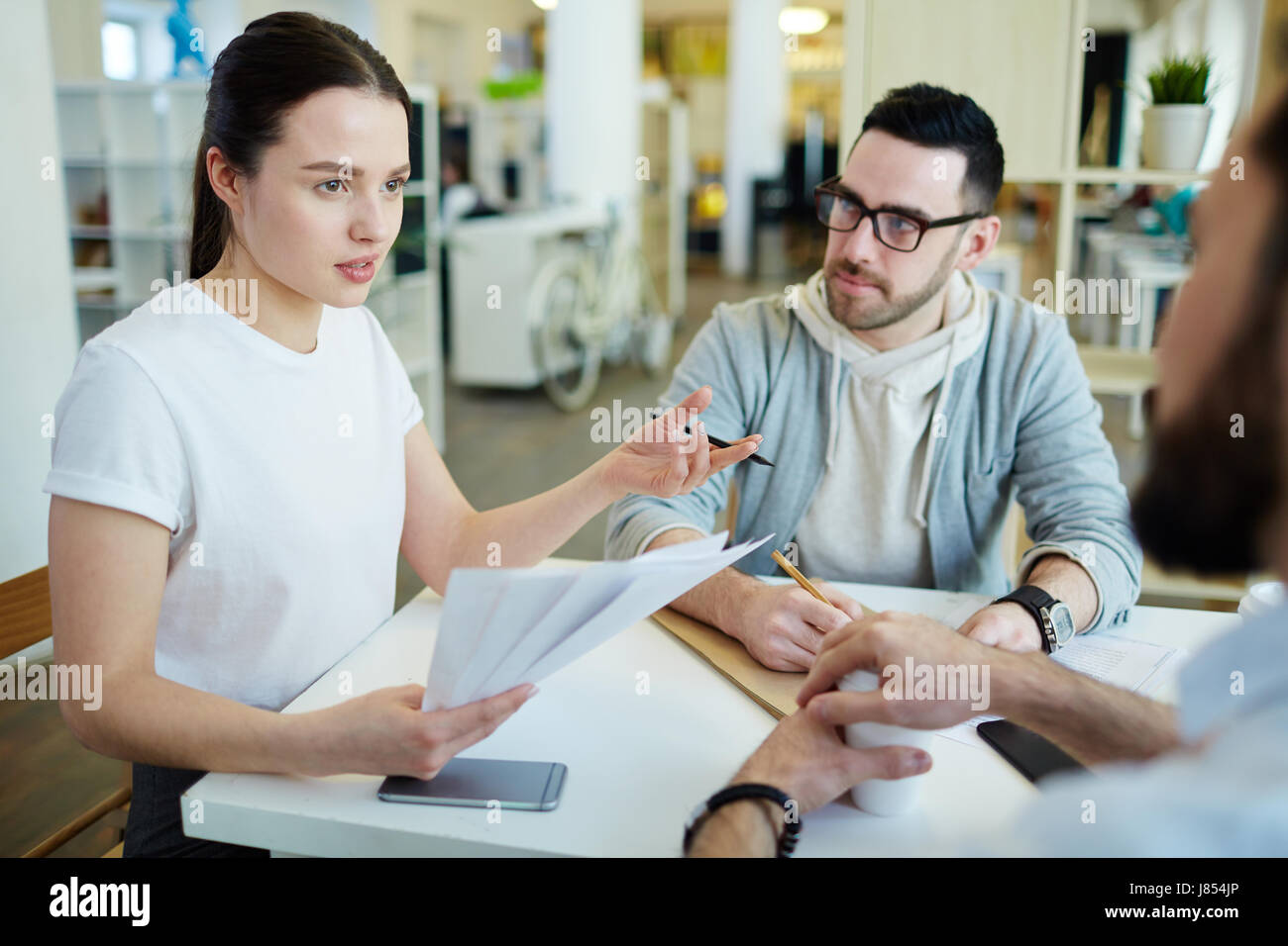 Portrait of three creative business people discussing project ideas and ...