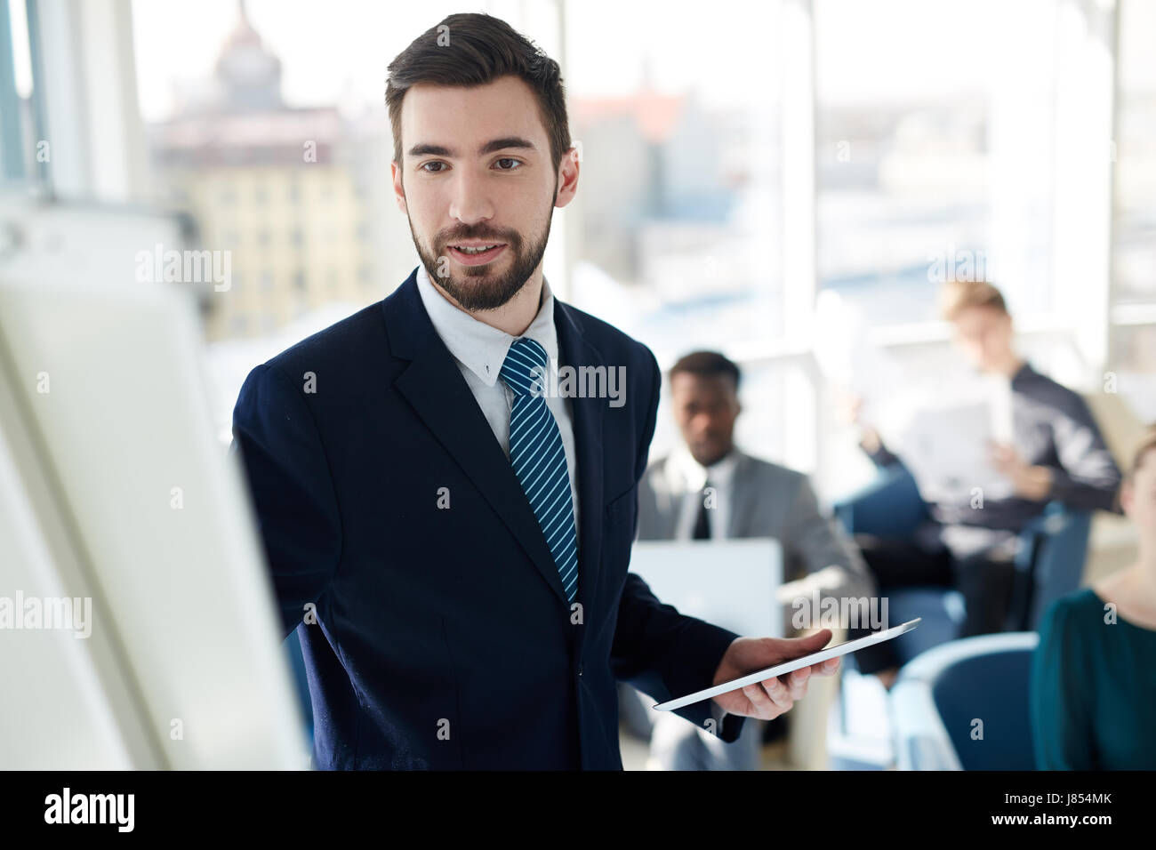 Portrait of handsome successful businessman standing at whiteboard ...