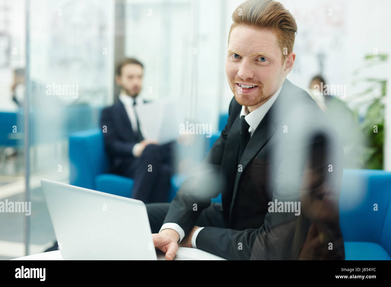 Modern business leader with laptop working in office Stock Photo - Alamy