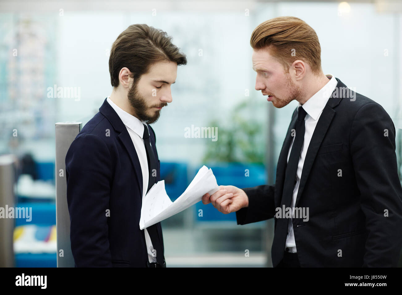 Boss reproaching one of employees after work Stock Photo - Alamy