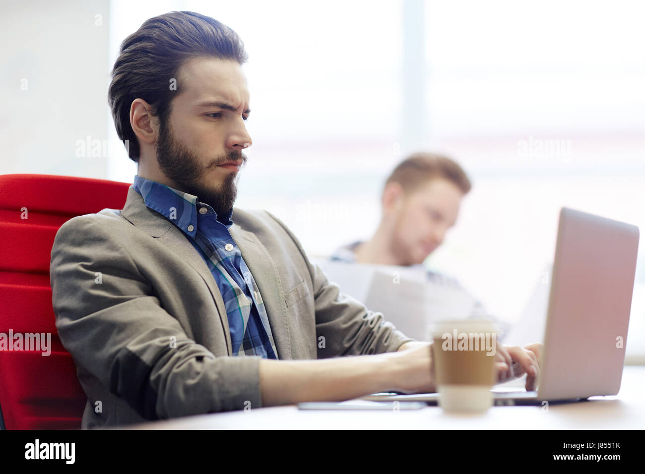 Serious office worker typing at workplace Stock Photo - Alamy
