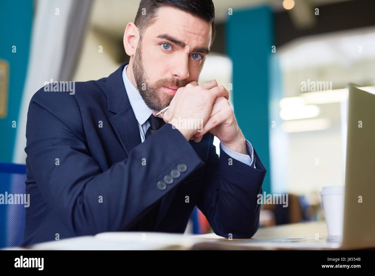 Serious boss looking at camera at workplace Stock Photo - Alamy